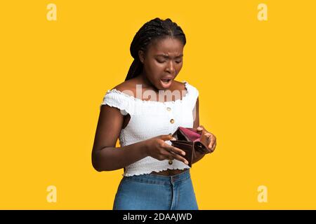 Poverty and absence of money. Shocked african american woman checking ...