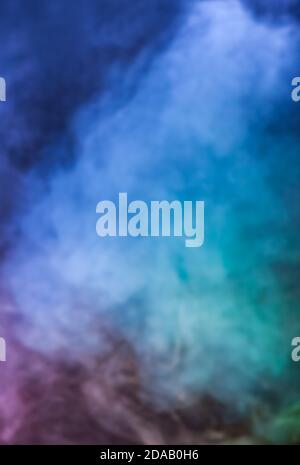 Defocused blurred image of colorful smoke on dark background. Texture ...