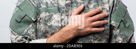 partial view of soldier in military uniform sitting on chair against ...
