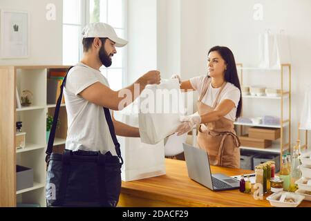 Express delivery service worker in medical mask with big food bag and ...