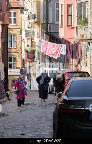 Muslim female friends in masks and with paper bags crossing road while ...