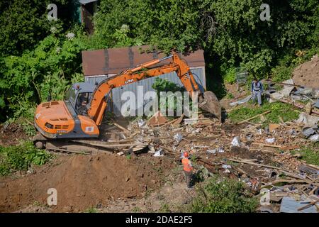 Excavator and builders destroy illegal buildings in the park Stock ...