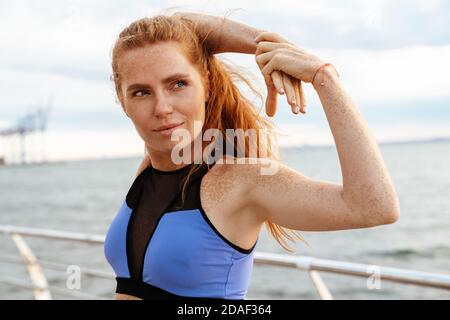 Image of redhead athletic sportswoman doing exercise while working out ...