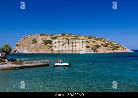 A small Greek fishing village and offshore island with crystal clear ...