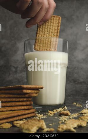Vertical shot of a person eating biscuits and a glass of milk Stock ...