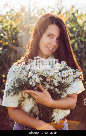 Portrait of beautiful woman with chamomile flowers indoors Stock Photo ...