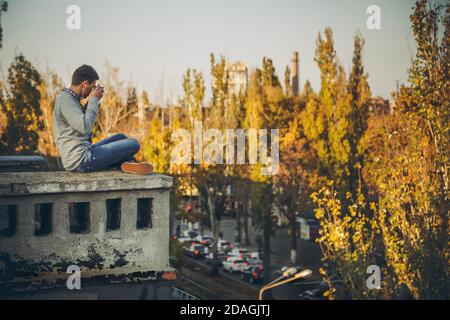 Depressed Teenager sit on the Roof Of Building Stock Photo - Alamy