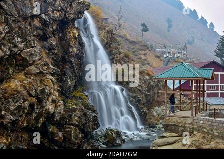 A visitor takes pictures of the waterfalls on an autumn day in Drang ...