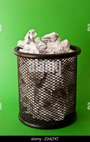 WASTE PAPER BIN FULL OF CRUMPLED PAPER AND FAX MACHINE ON WOOD OFFICE ...