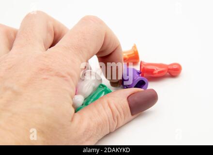 Women's hand with a manicure rakes in a bunch of little plastic ...