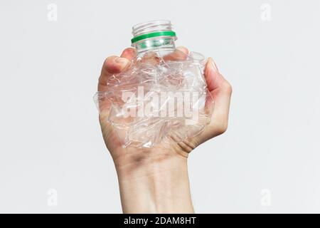 Man smashing a plastic bottle with his hand on white background Stock ...