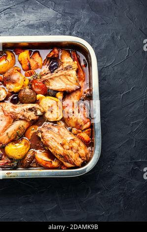 Rabbit stewed in red wine with vegetables and garlic close-up in a ...
