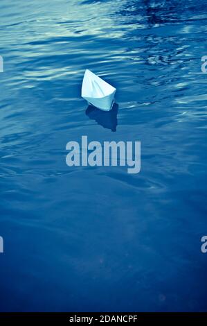 Folded paper boat floating in water Stock Photo - Alamy