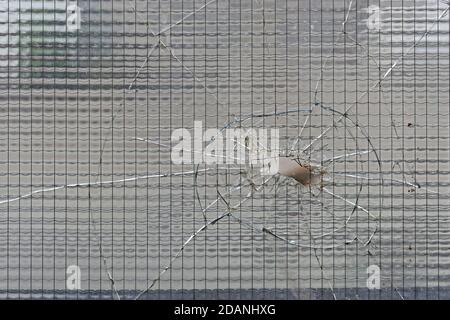 Broken safety tempered glass with big hole damage Stock Photo - Alamy