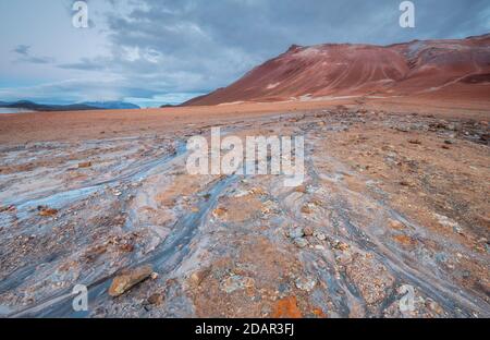 A natural spring of water flows from the hillside in the mountains of ...