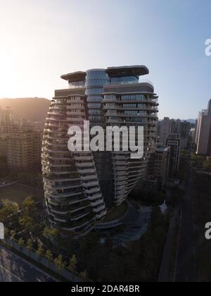 Modern, twisted high-rise architecture against a clear blue sky with ...