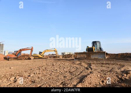 Excavators and dozer digs ground at a construction site for installing ...