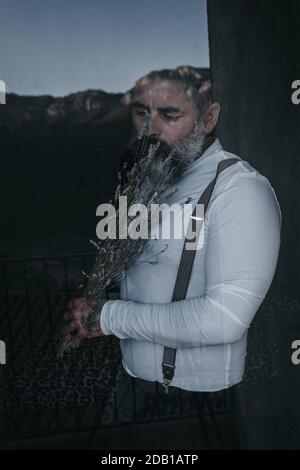 Man smelling lavender flower standing in field Stock Photo - Alamy