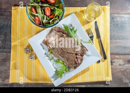 a Breton crepe with cheese and bacon in white plate Stock Photo - Alamy