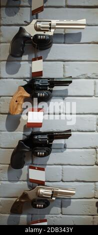 Assortment of pistols for sale on display of gun shop Stock Photo - Alamy