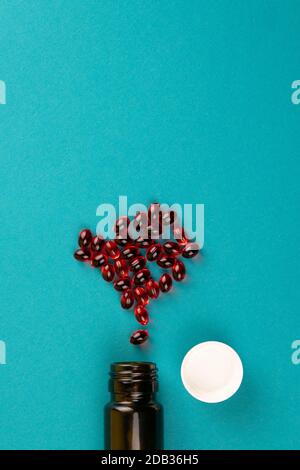 Red tablets are poured from a white plastic jar. Photo on white ...