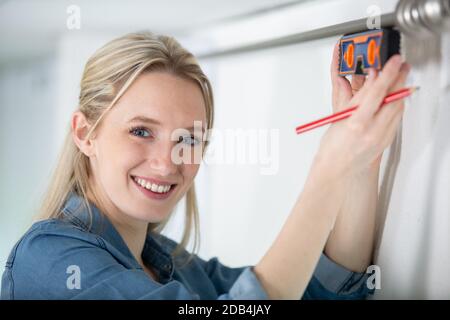 woman checking curtain rail with a spirit level Stock Photo - Alamy