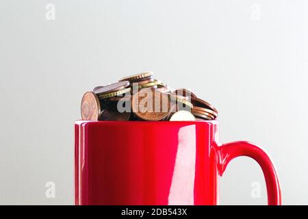Saved Money in a colorful red mug to Finance Goals overflowing with ...