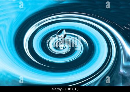 Abstract circular movement of water with a drop in the middle. A splash ...