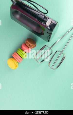 Colorful macaroons and mixer on mint background. Top views with clear ...