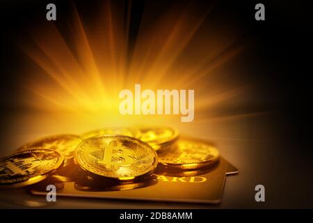 Shining pile of golden bitcoins and gold credit card in bright rays ...