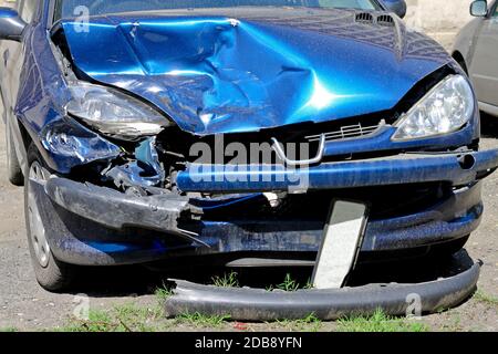 Small blue car smashed at frontal impact Stock Photo - Alamy