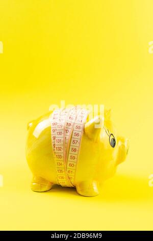 a measuring tape and a piggy bank in a white plate Stock Photo - Alamy