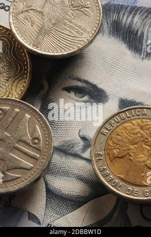 Macro closeup of Colombian peso banknotes and coins on white background ...