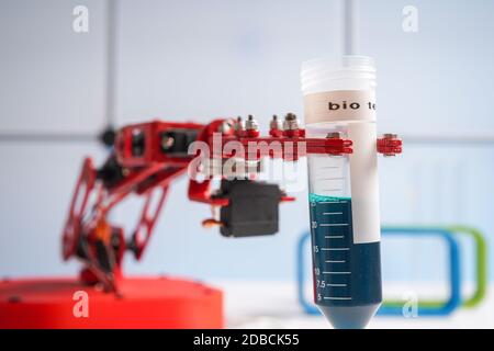 Robot arm with test tube with biological sample in science laboratory ...