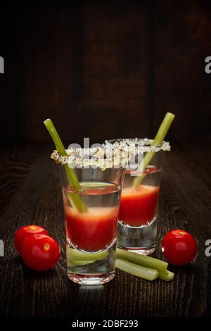 Board with glasses of bloody mary cocktail garnished with bacon on ...