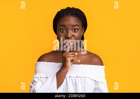Keep silence. Young african american woman showing shhh sign at camera ...