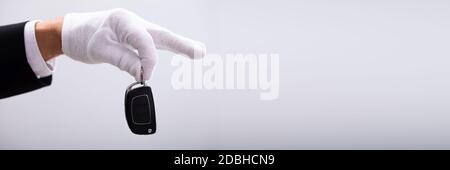 Valet's Hand Holding Car Key Against White Background Stock Photo - Alamy