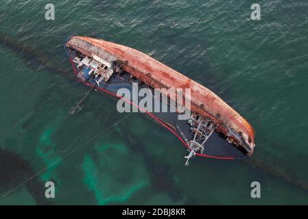 Sunken drowned tanker ship near the aground. Broken rusty ship on the ...