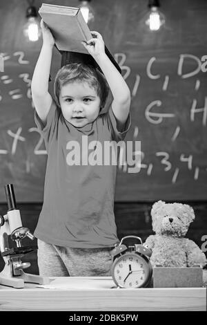 Wunderkind child boy on chalkboard background with science formula and ...