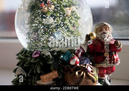 Glass ball with snow along with Santa Claus and gifts Stock Photo - Alamy