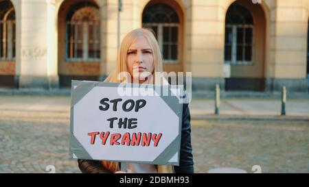 Young woman calling to stop the tyranny by holding steamer. Protest ...