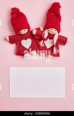 Toy midgets with greeting card on the rose background Stock Photo - Alamy