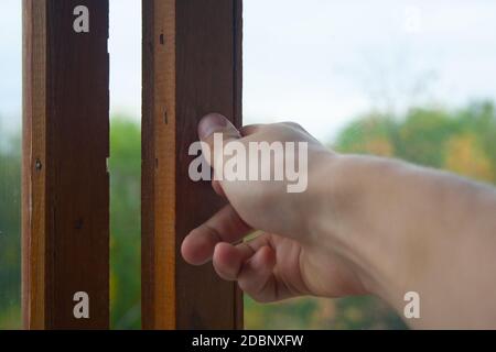 Hand closing the window at cold weather. Winter is coming, close window ...