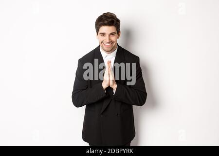 Handsome guy saying thank you, bowing and holding hands in namaste ...