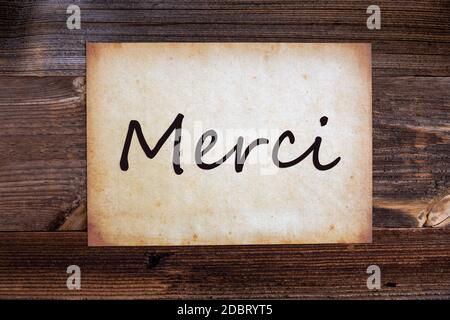 Old Paper, Merci Means Thank You, Wooden Background Stock Photo - Alamy