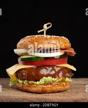 cheeseburger with tomatoes, onions, barbecue cutlet and sesame bun on ...