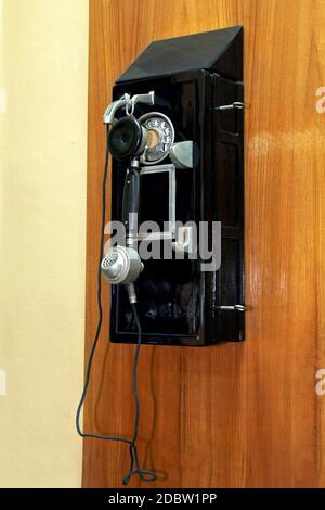 A vintage payphone mounted on a wall, surrounded by colorful graffiti ...