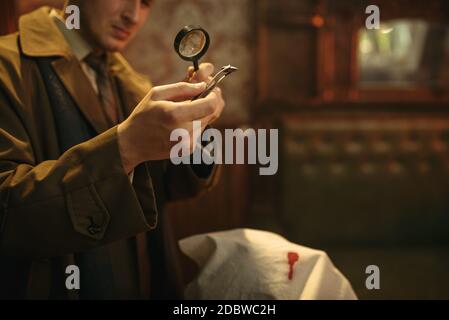 Detective looks evidence through magnifying glass Stock Photo - Alamy