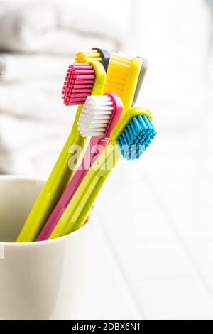 Various colorful toothbrushes in cup Stock Photo - Alamy