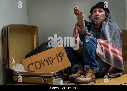A homeless person holds a sign asking for help during a cold day in ...